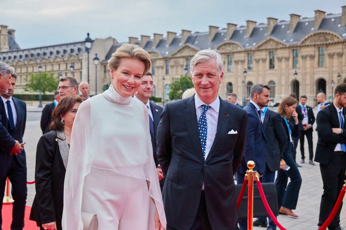 La reine Mathilde en majesté et cape au vent devant la Pyramide du Louvre